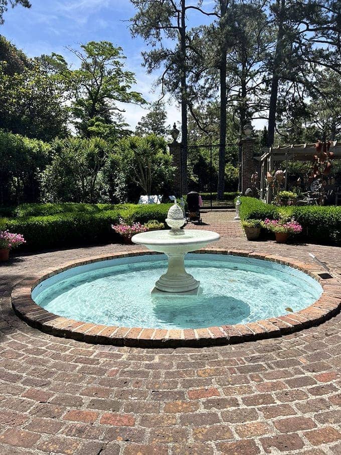A turquoise fountain sparkles in the courtyard like someone dropped a piece of Caribbean sky.