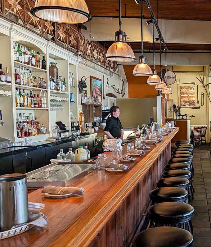 The bar stretches invitingly along the space, offering prime real estate for solo diners who appreciate good food and better company.