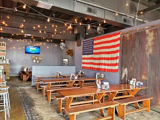 Picnic tables under string lights and an American flag, because barbecue is as patriotic as it gets, folks.