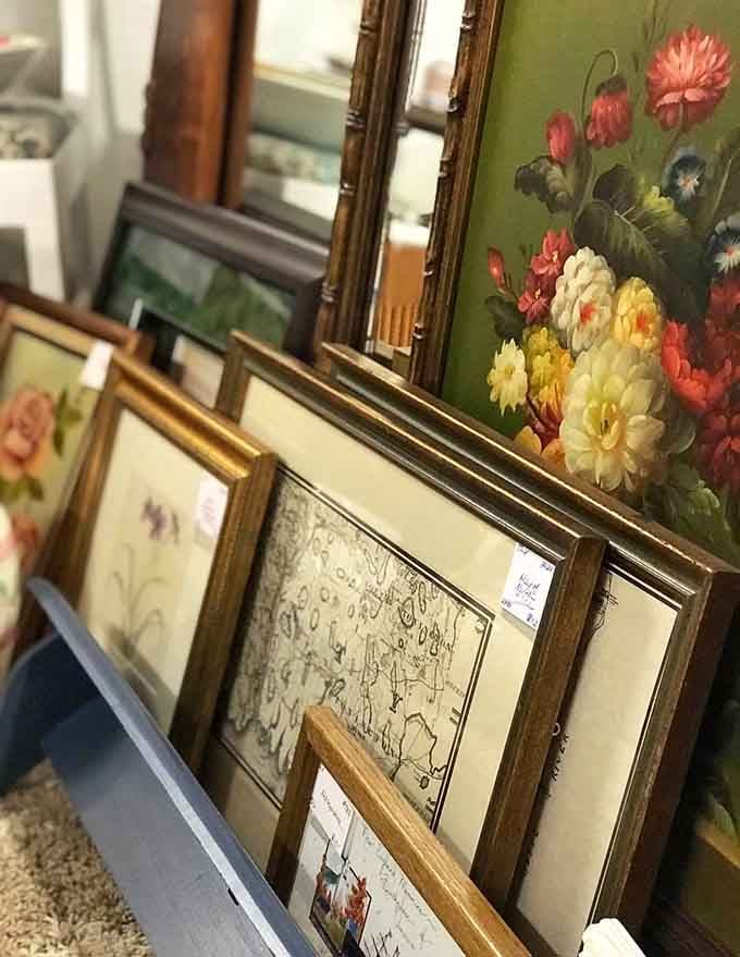 Framed florals and sketches lean patiently against each other, waiting for the perfect wall to call home again.