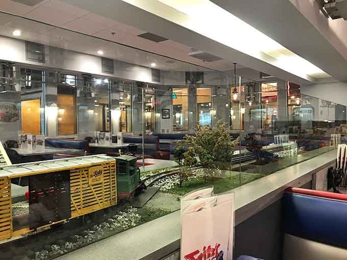 The miniature railroad display case showcases the intricate track system, giving you something fascinating to study between bites of burger.