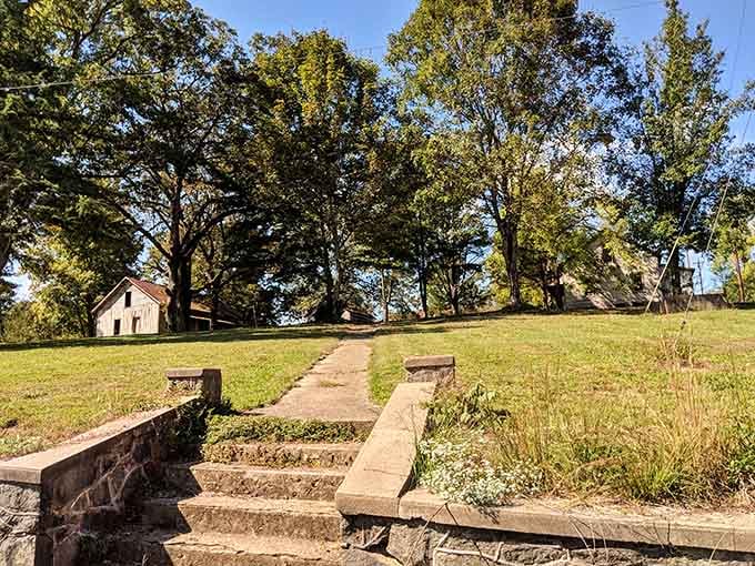 Stone steps lead upward to memories of community gatherings, now hosting only moss, weeds, and the occasional curious visitor.