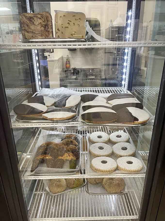 Black-and-white cookies and rugelach wait patiently behind glass for anyone with room left after those sandwiches.