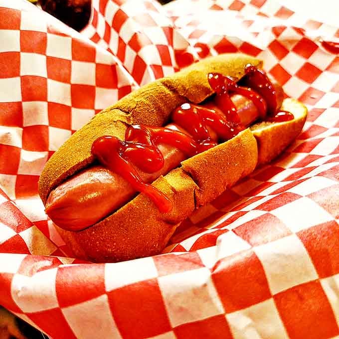 The hot dog, dressed simply with ketchup on a classic bun, proves that sometimes the straightforward approach wins the flavor race.