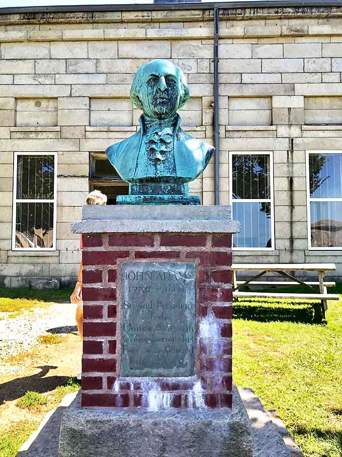 John Adams watches over the fort that bears his name, his weathered copper visage a reminder of the early presidents who shaped America's defenses.