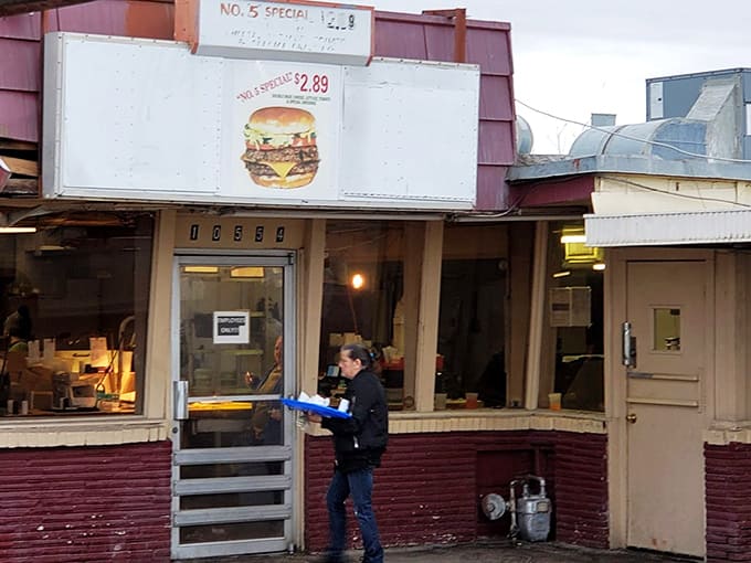 The friendly face behind the window, keeping decades of drive-in tradition alive one order at a time.