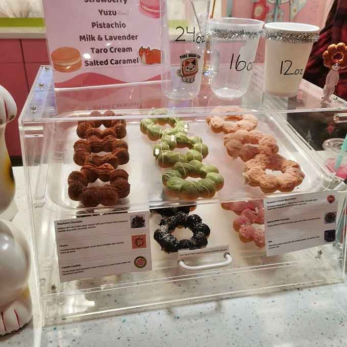 Mochi donuts in various flavors sit behind glass like edible works of art waiting for their close-up moment.