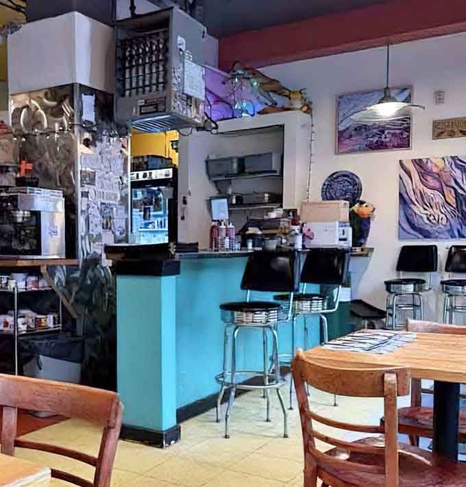 That turquoise counter and stacked coffee mugs signal a place where caffeine flows freely and conversation comes naturally.