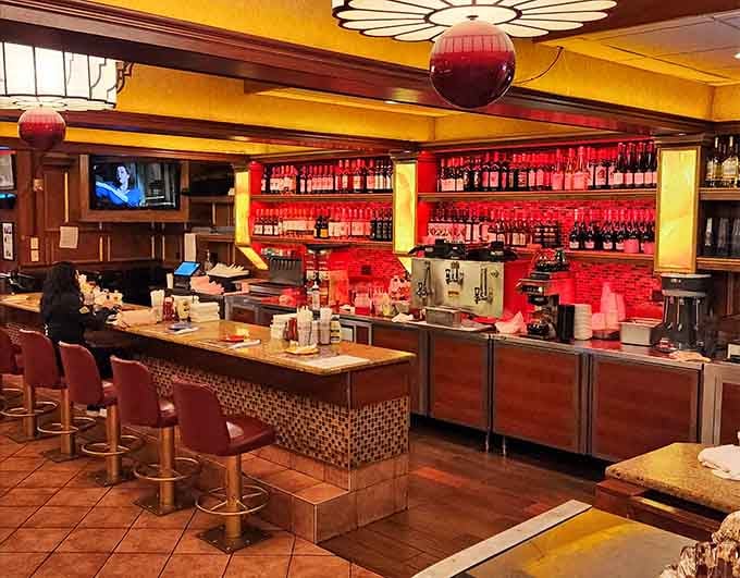 That bar area gleams with possibility, red tile backsplash, and enough bottles to make any evening interesting.
