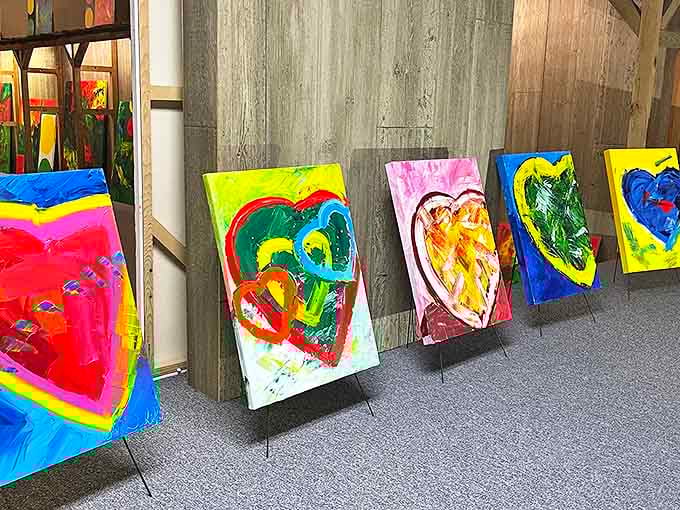 Vibrant heart-themed artwork lines the gallery wall, each canvas a kaleidoscope of color and emotion &ndash; proof that artistic passion thrives in this literary prairie town.