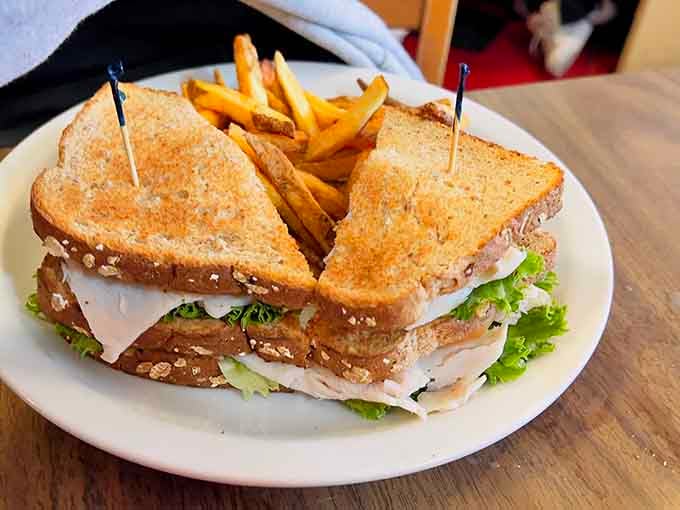 The chicken club arrives stacked high on wheat toast, proving sandwiches can be both simple and spectacular.