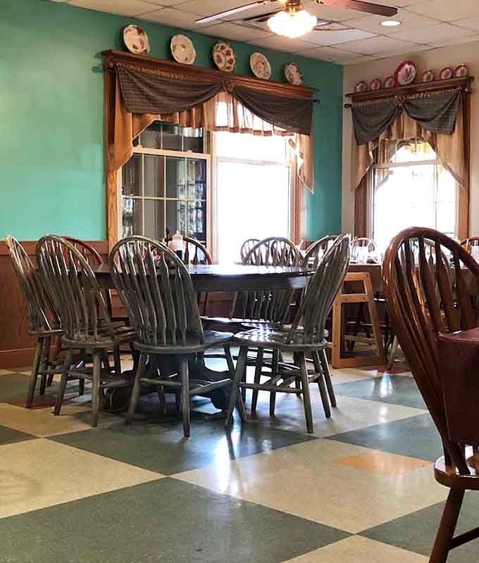 Decorative plates on the walls and curtained windows create an atmosphere that feels like Sunday dinner every day.