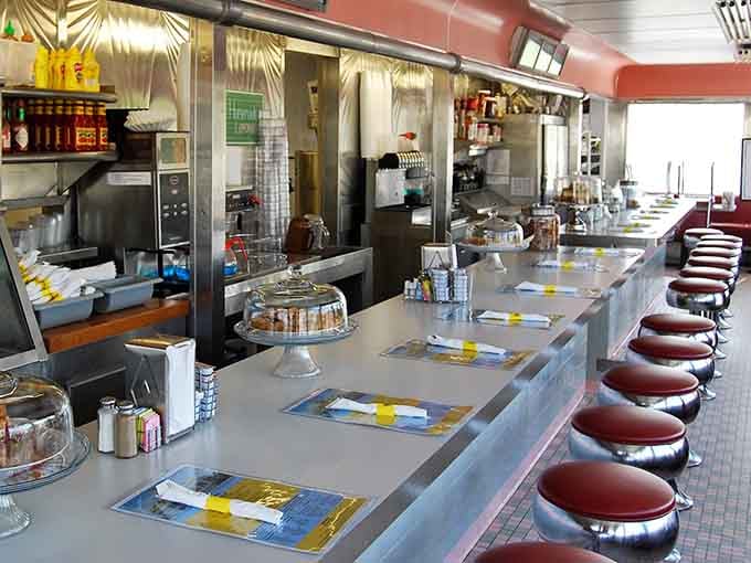 The counter stretches invitingly with swivel stools ready for solo diners seeking front-row seats to the diner action.