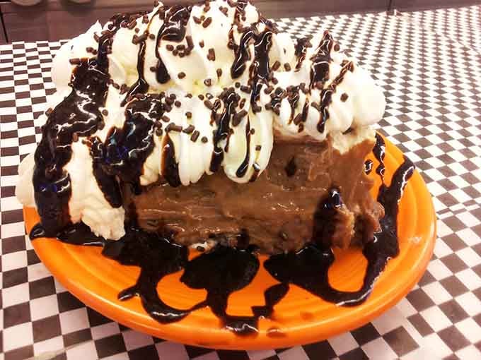 Chocolate brownie topped with whipped cream and drizzle is dessert doing exactly what dessert is supposed to do: make you happy.