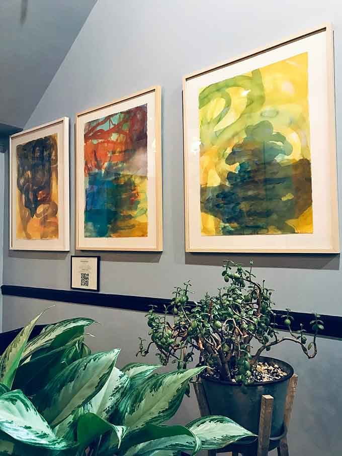 Colorful abstract artwork adorns the walls, adding visual interest and celebrating local artistic talent throughout the dining space.