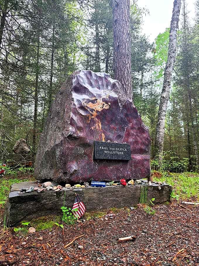 The Wellstone Memorial marks a solemn spot in the forest where Minnesotans remember a beloved political figure with stones, flags, and quiet reflection.