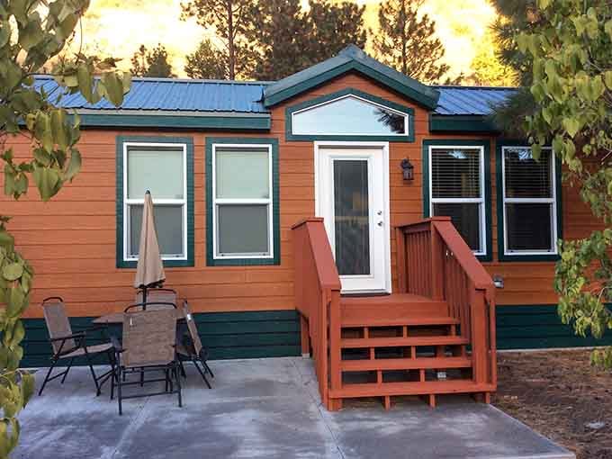 Tiny cabin with a patio setup that proves retirement living doesn't require a mansion to feel like home.