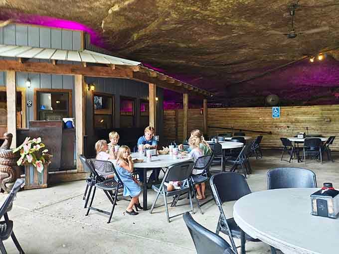 Diners enjoying their meals under purple lights and ancient stone, creating memories that no chain restaurant could ever match.