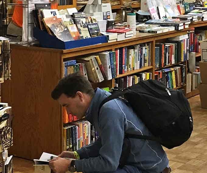 This shopper's absorbed in his find, experiencing that perfect moment when the right book chooses you.