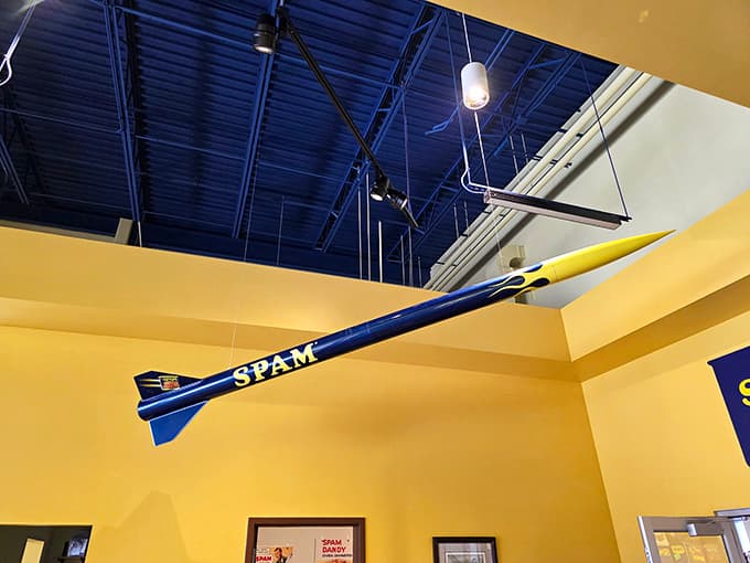 A SPAM rocket hangs overhead because why shouldn't processed meat have space-age aspirations and dreams of flight?