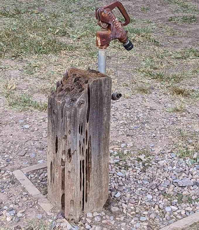 This rusted water pump on weathered wood perfectly captures the harsh reality of desert life in frontier Arizona.