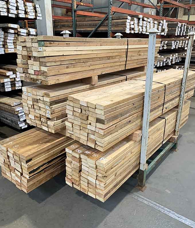Stacks of lumber organized with the precision of someone who actually knows what they're doing with building materials.