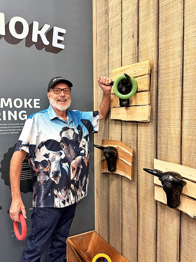 A gentleman demonstrates proper smoke ring technique with infectious enthusiasm. In barbecue, as in life, sometimes you just need to throw your whole self into it.