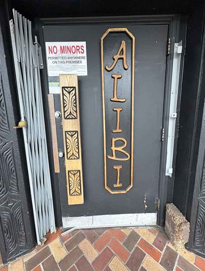 The entrance door promises "Alibi" in carved letters, your perfect excuse for being fashionably late to everything else.