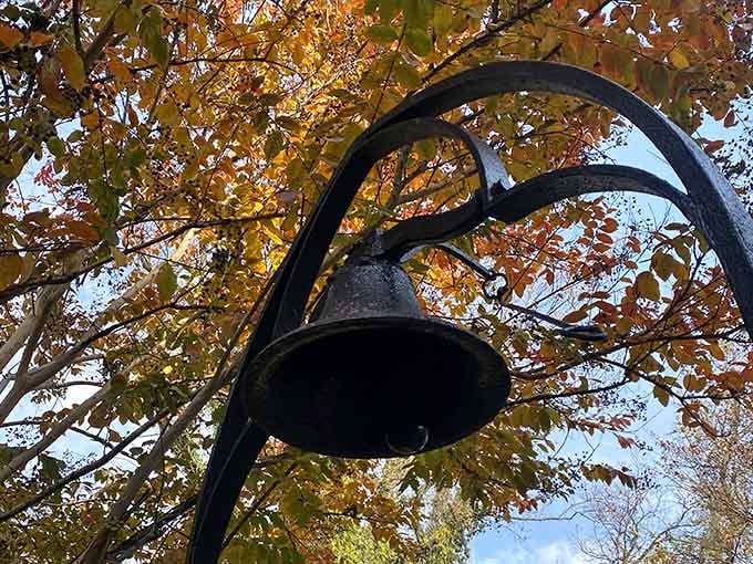 An outdoor bell framed by autumn leaves adds authentic charm to the castle grounds experience.