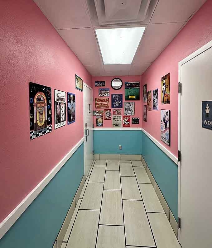 Even the hallway to the restrooms commits fully to the retro aesthetic with pink walls and vintage posters.