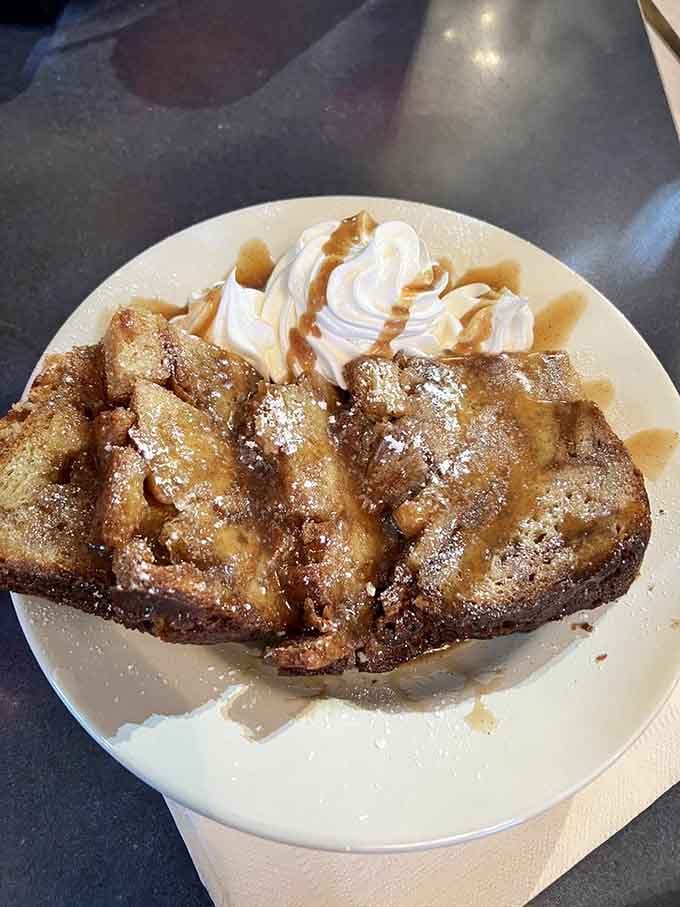 Bread pudding with caramel and whipped cream towers like a sweet monument to excellent life choices.