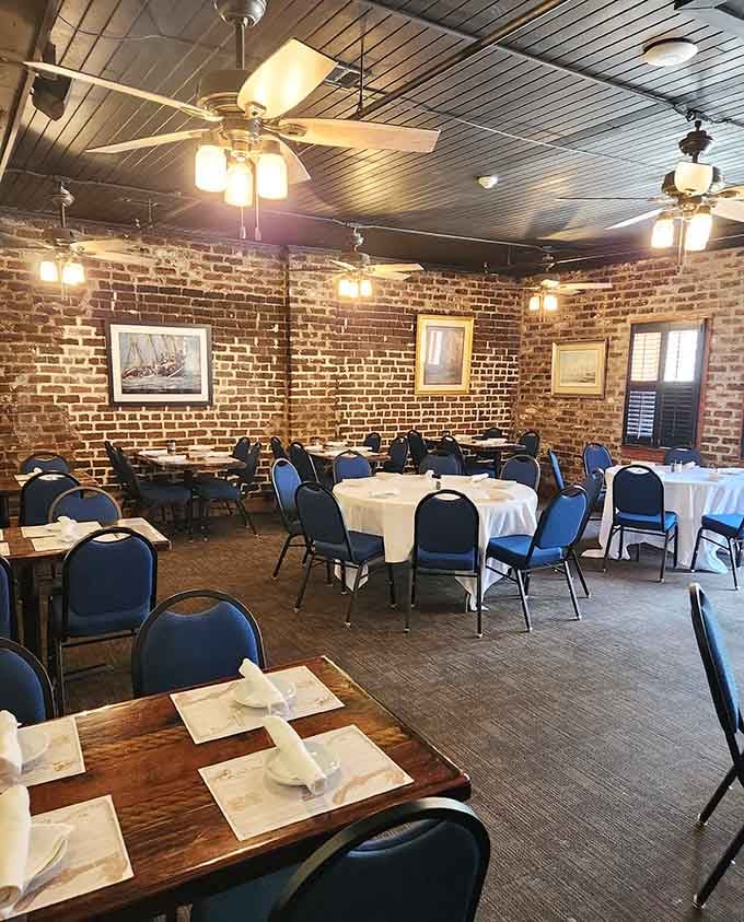 White tablecloths against exposed brick walls create a dining room that respects both history and your appetite for good food.