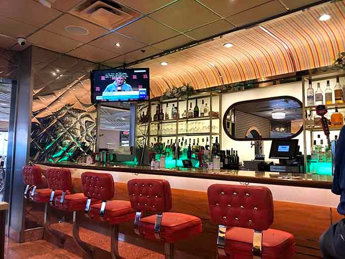 The bar area gleams with promise, offering liquid refreshment to complement your mountain of comfort food ahead.