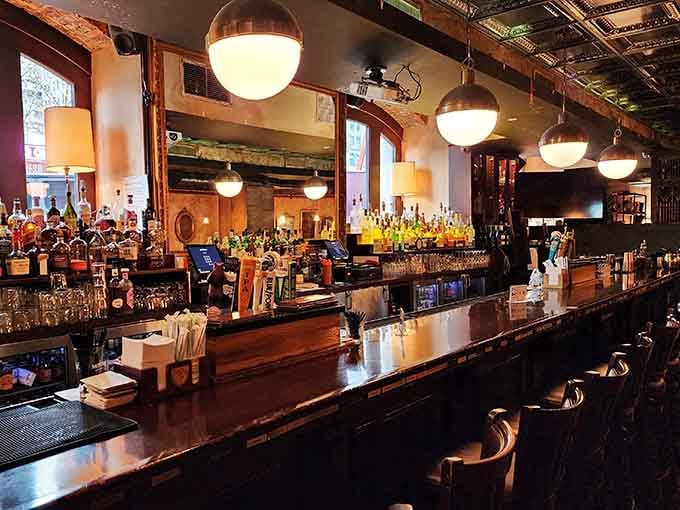 The polished bar stretches invitingly beneath globe lights, offering craft cocktails where bankers once counted their fortunes daily.