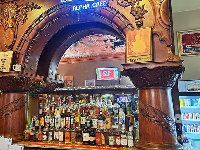Ornate woodwork frames bottles like liquid artwork, where every pour comes with a side of architectural eye candy.