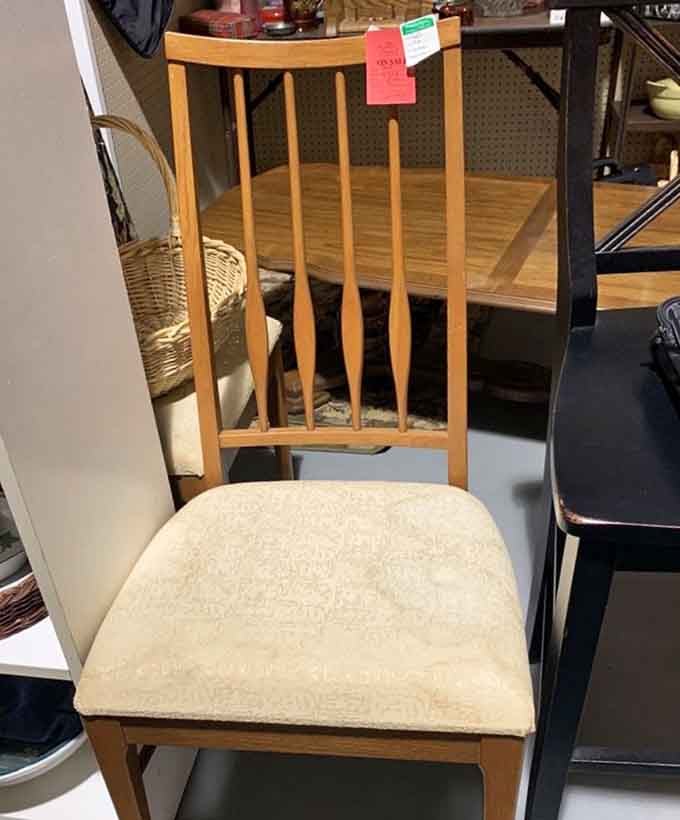 Mid-century dining chair with clean lines and creamy upholstery&mdash;the kind Don Draper would casually drape his suit jacket over while mixing an Old Fashioned.