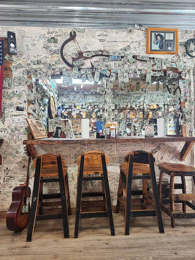 The wall of memories where diners leave their mark. Dollar bills, business cards, and handwritten notes create a tapestry of shared experiences around great food.