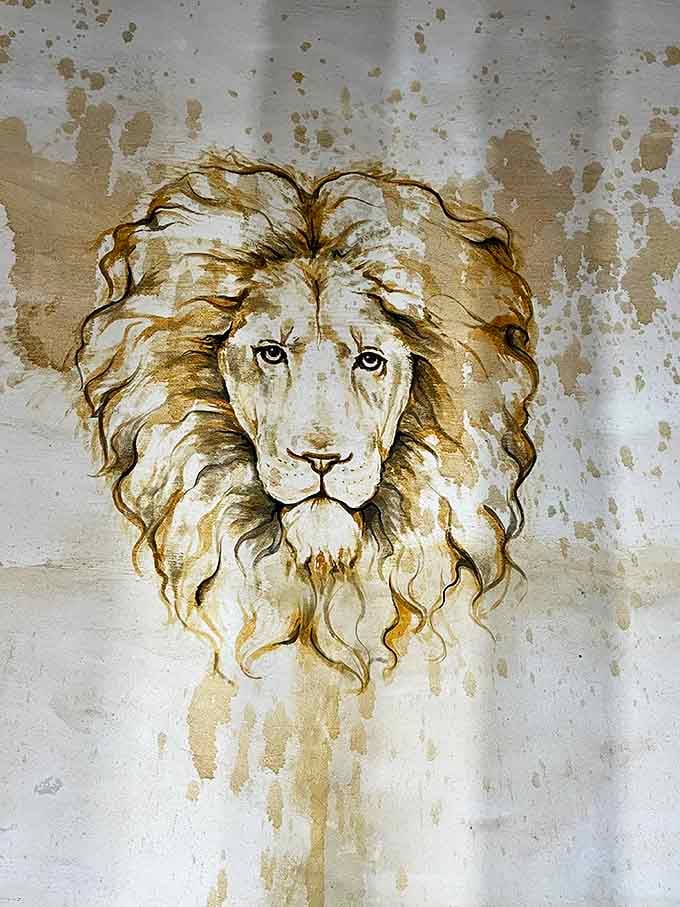 Not your typical beach art&mdash;a regal lion watches over visitors, its golden mane and knowing eyes painted directly onto the castle's interior wall.