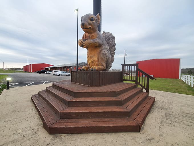 Ms. Pearl clutches her acorn while standing tall on wooden steps, greeting visitors with an oversized smile.