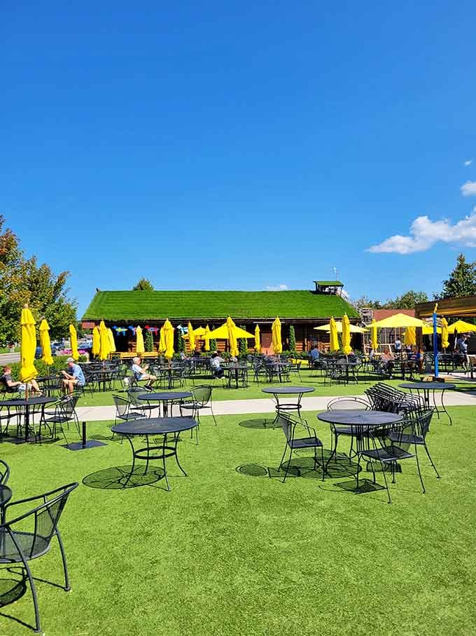 Outdoor seating under bright yellow umbrellas with that famous grass roof overhead—al fresco dining with a side of goats.