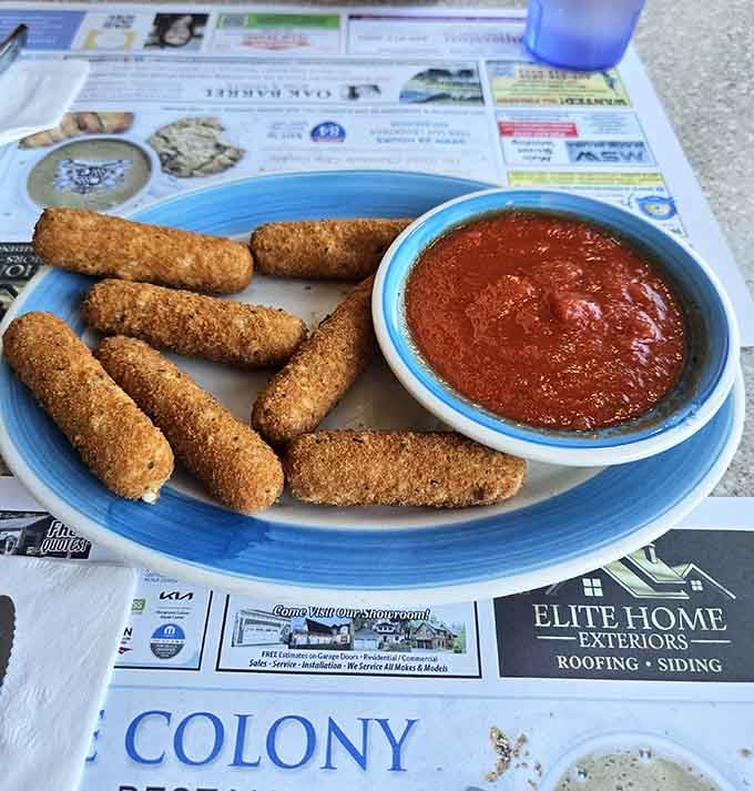 Golden mozzarella sticks with marinara sauce, proving that sometimes the simplest pleasures are the most satisfying ones.