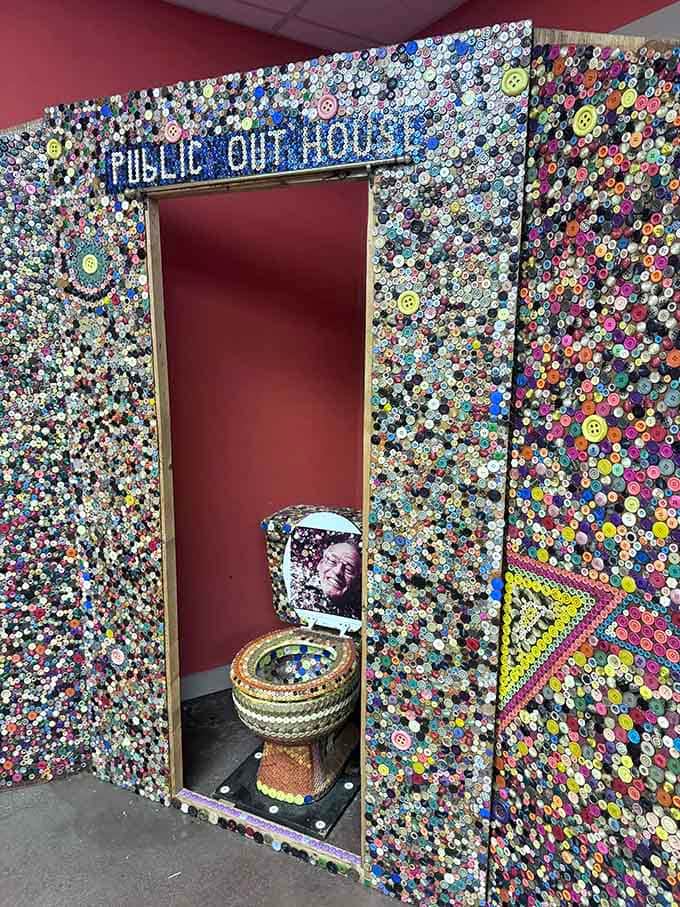 The public outhouse entrance is completely covered in buttons, making even bathroom breaks an artistic experience here.