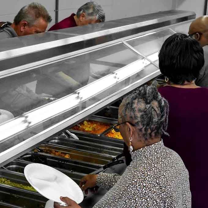 The buffet line in action: where decisions are made, plates are filled, and dietary resolutions go to rest.