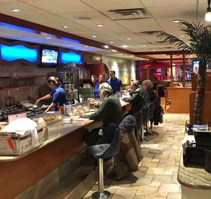 The counter seating with tropical screens and palm plants offers front-row seats to the culinary action happening behind the scenes.