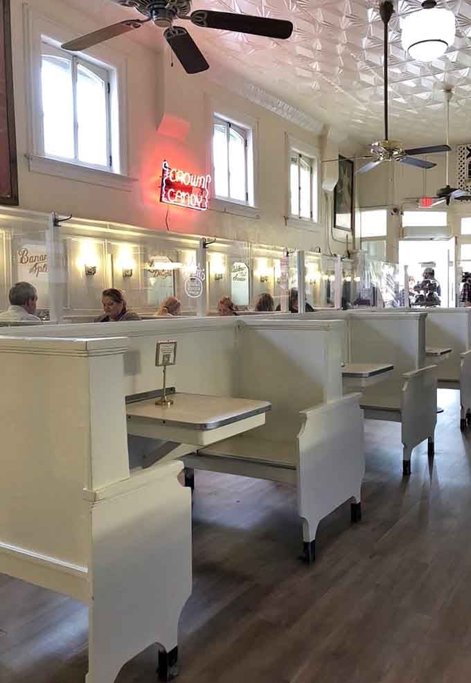 Classic booth seating under that glowing neon sign creates the perfect backdrop for making memories.