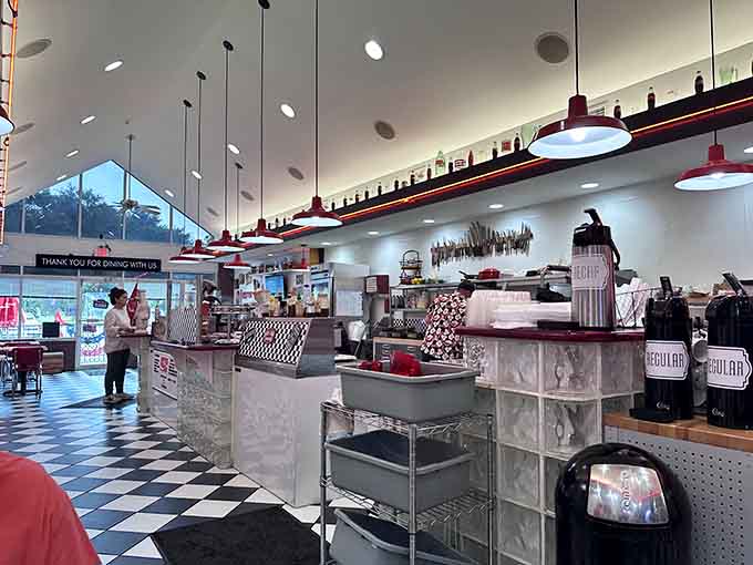 The counter stretches invitingly under those red pendant lights, perfect for solo diners who enjoy watching the kitchen magic happen.