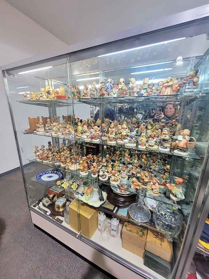 Hummel figurines crowd the shelves like a porcelain family reunion, each cherubic face sweeter than the last one.