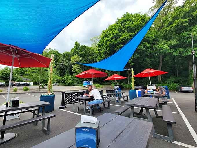 Red umbrellas shade the outdoor seating area, perfect for enjoying your meal on a beautiful Connecticut day.