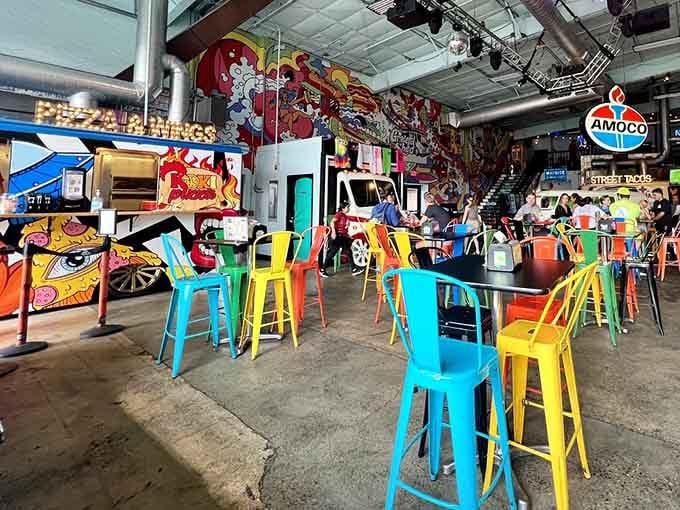 Mismatched colorful chairs and vintage food trucks create a dining room that celebrates joyful chaos beautifully.
