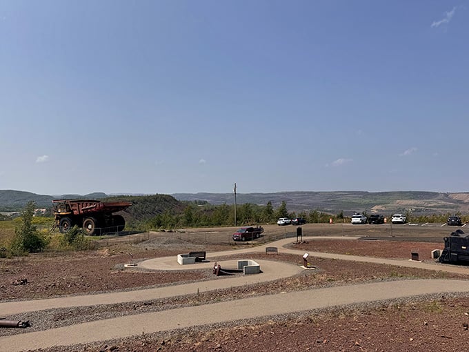 That massive mining truck dwarfs everything nearby, standing guard over the enormous pit that literally moved an entire town.